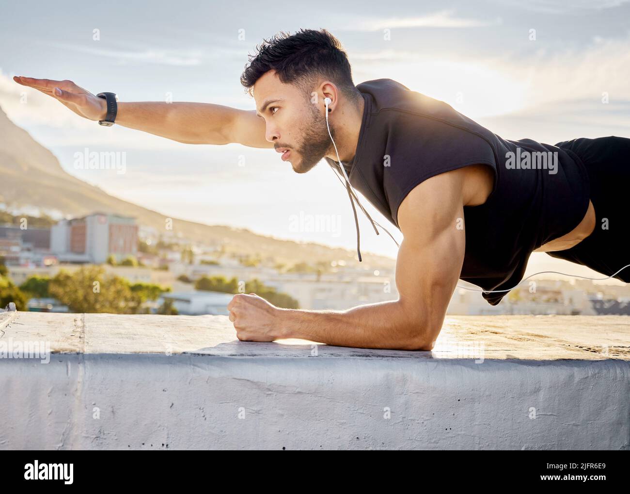 Just keep pushing forward. Shot of a man doing a single-arm plank while ...