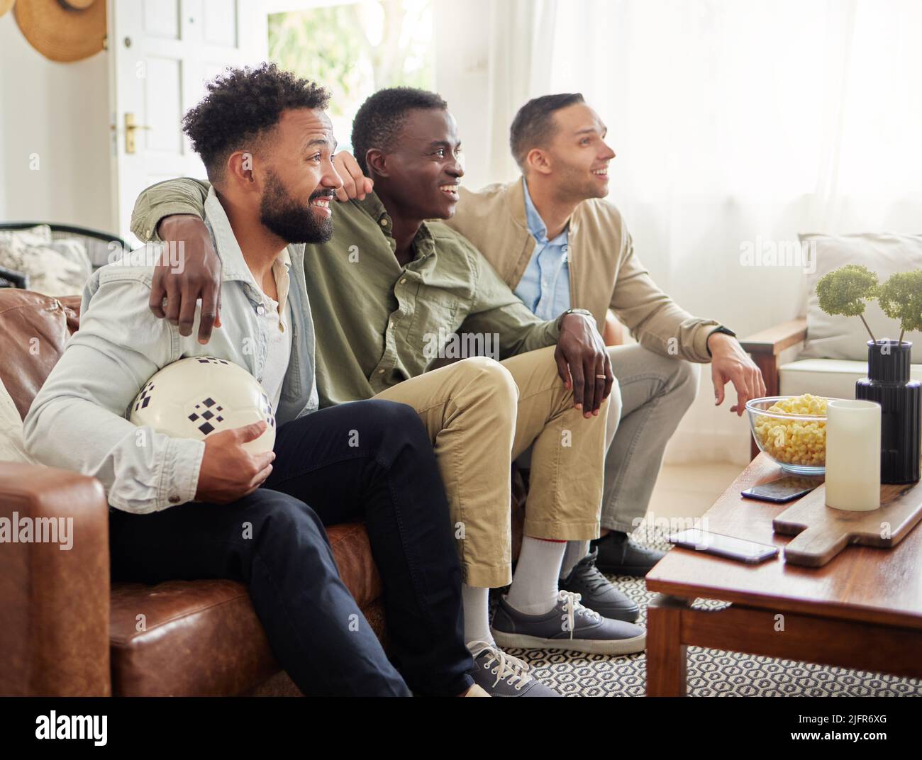 Three people sitting on couch hi-res stock photography and images - Alamy