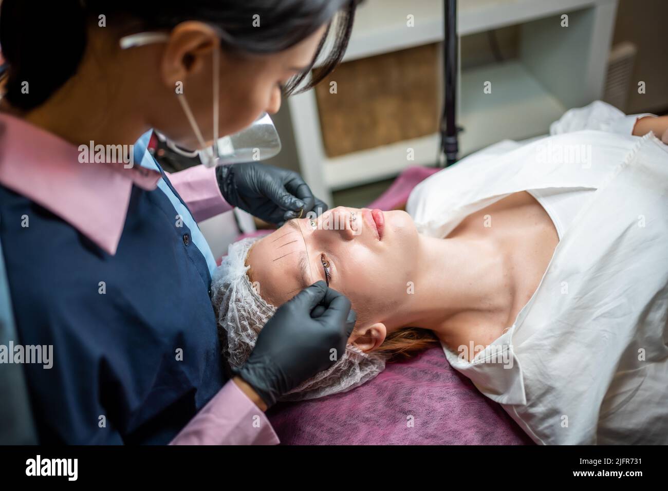 Permanent makeup cosmetologist master takes measurements for the new ...