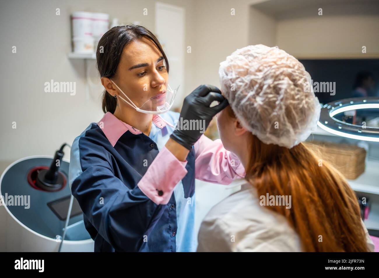 Permanent makeup cosmetologist master takes measurements for the new ...