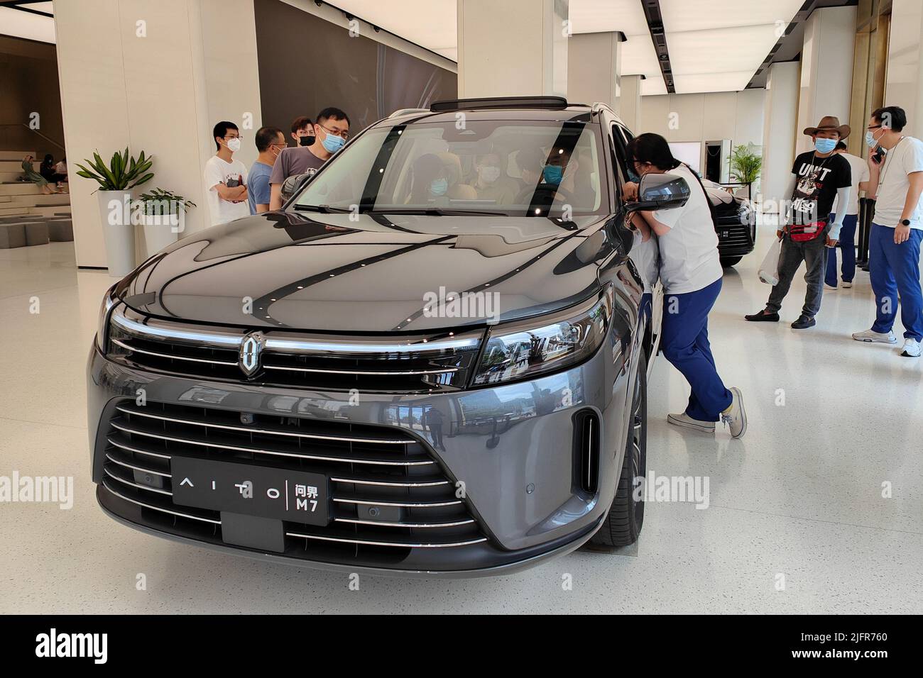 Customers check out huawei's newly released AITO M7 model at huawei's ...