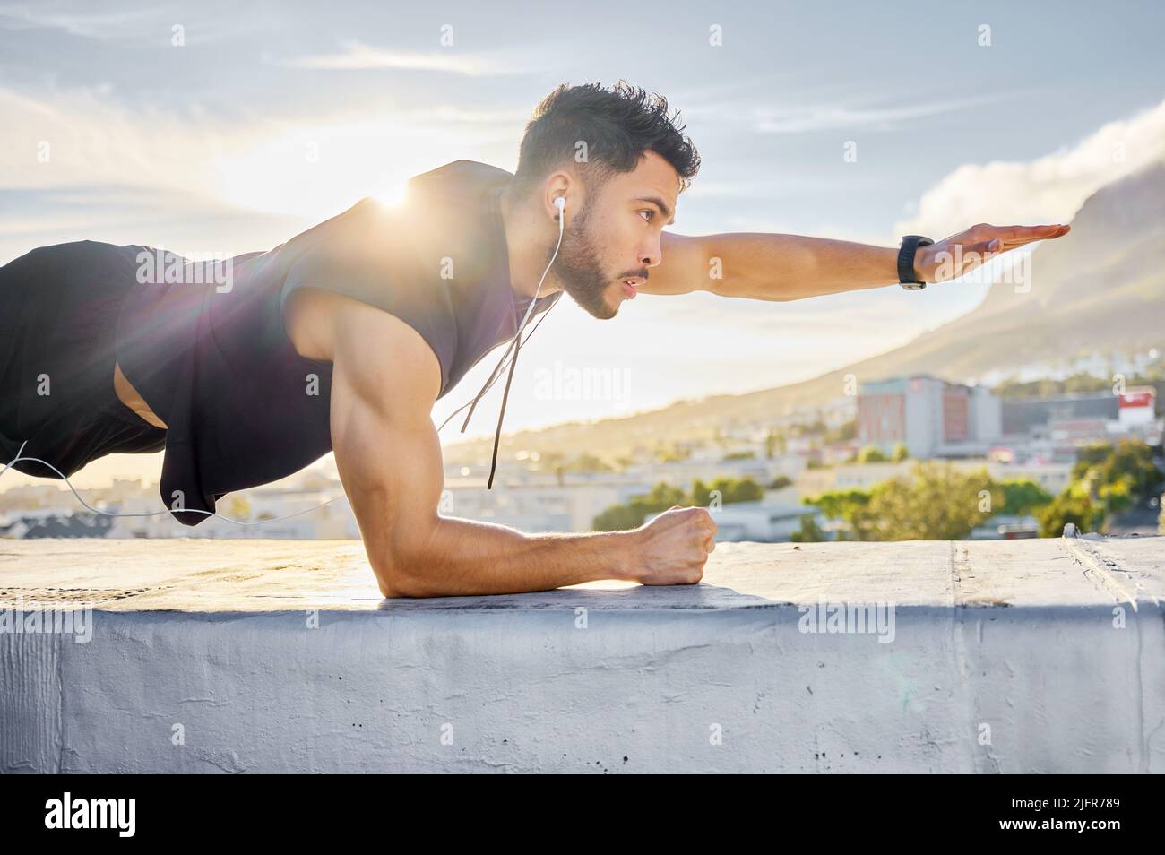 Im targeting my core. Shot of a man doing a single-arm plank while on a ...