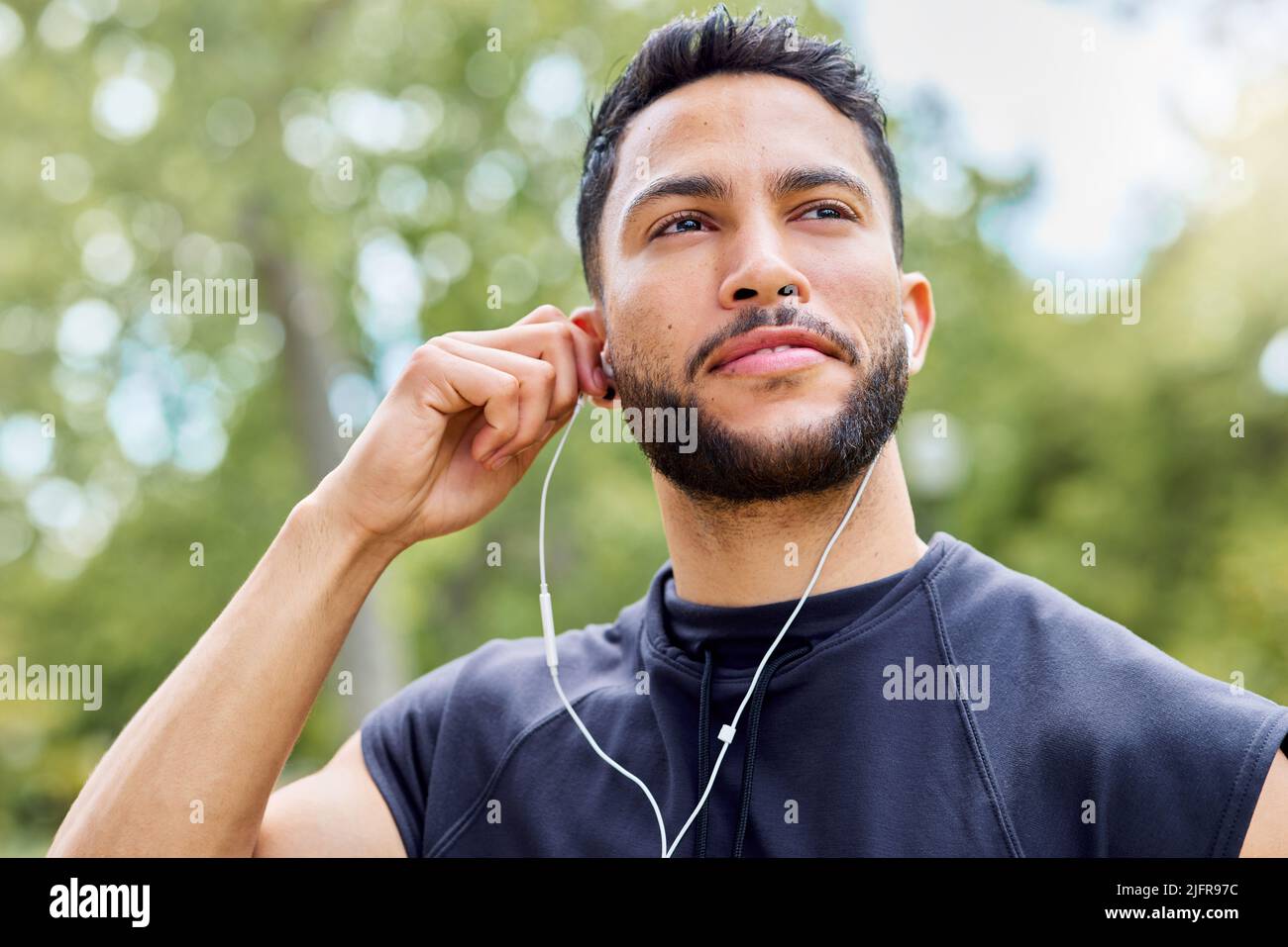 Pump the playlist thatll make you run further. Shot of a sporty young ...