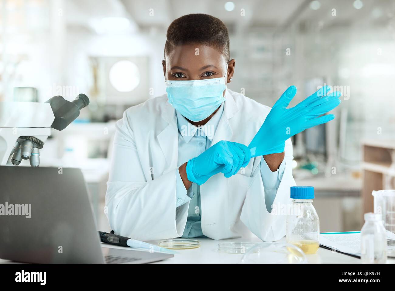 Im ready to work with samples. Shot of a young scientist sitting alone ...
