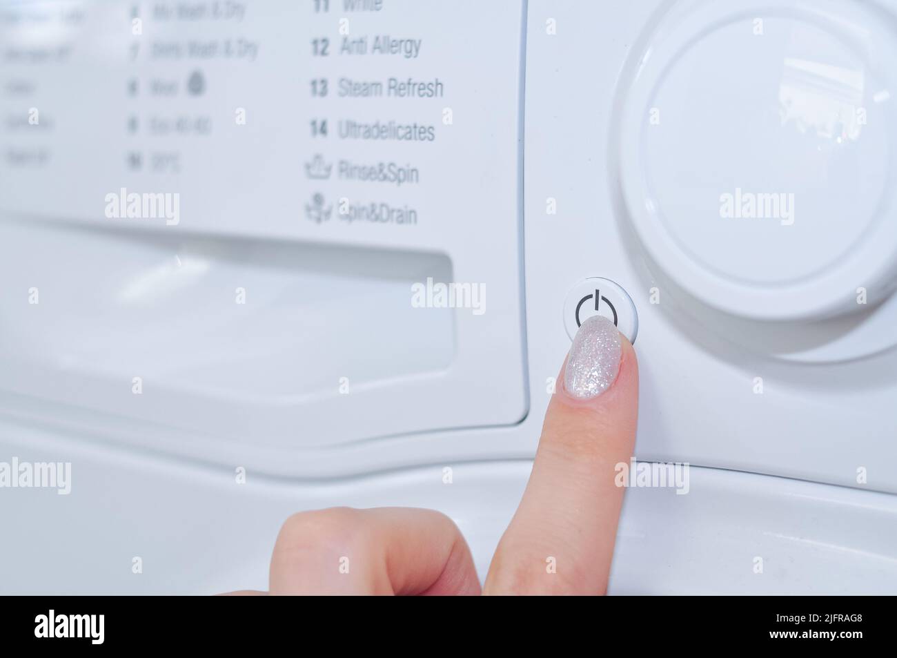 close up of women's finger pushing the button on the washing machine ...