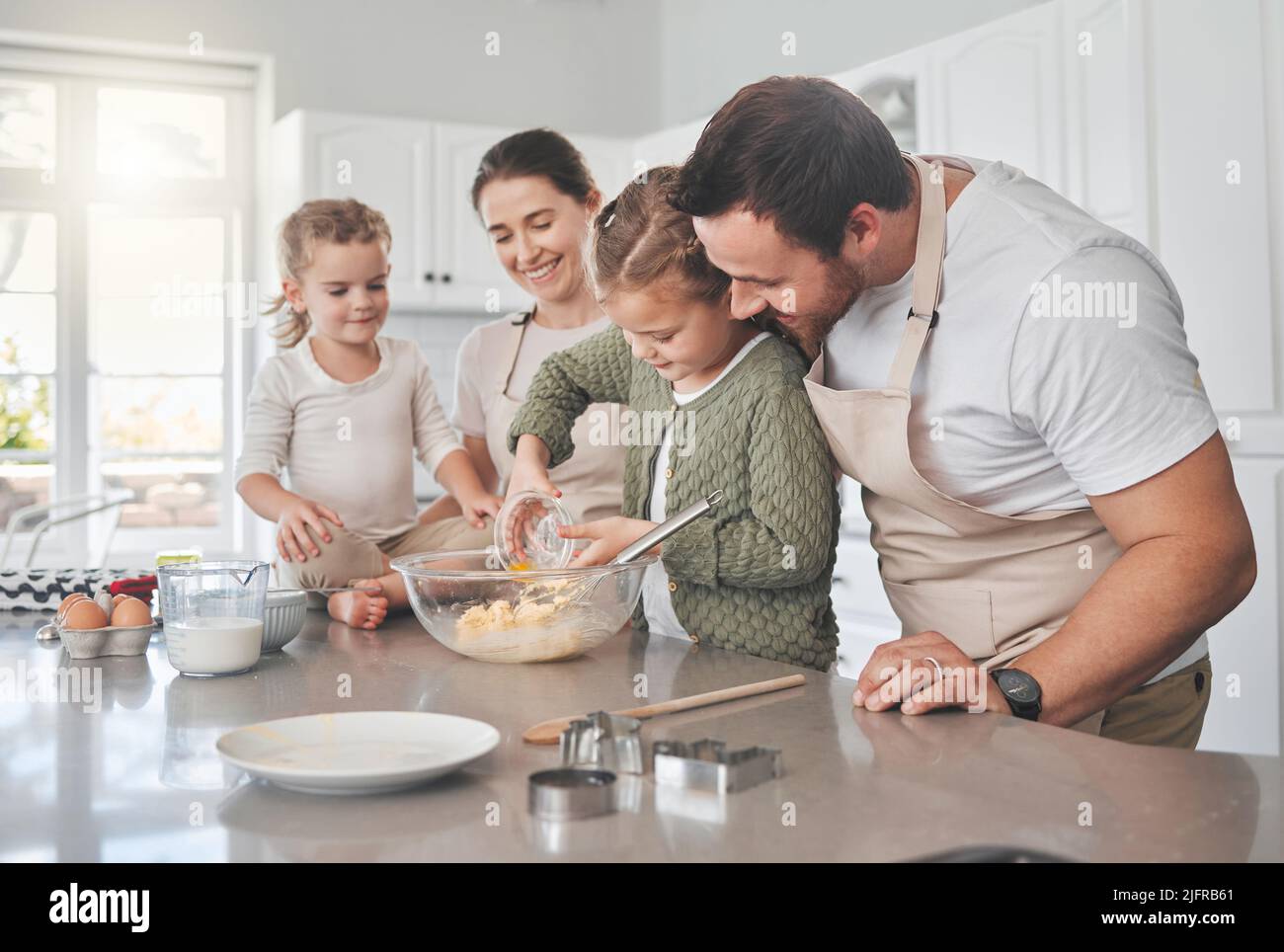 Baking cookies is comforting. Shot of a family baking together in the ...