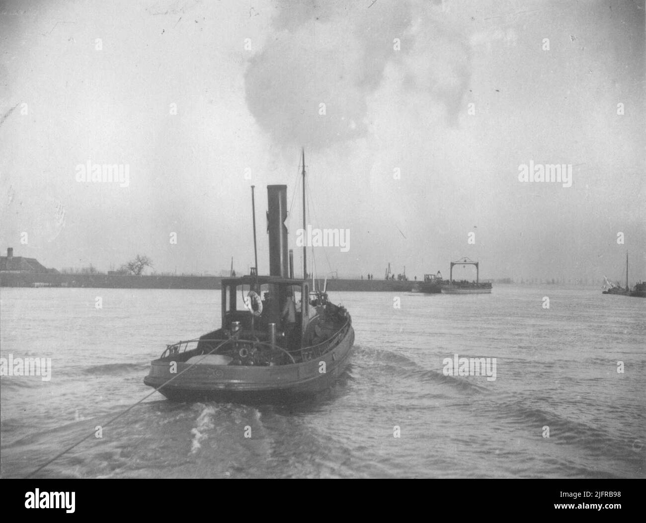 A tugboat on the river Waal, with the ferry in the background Stock ...