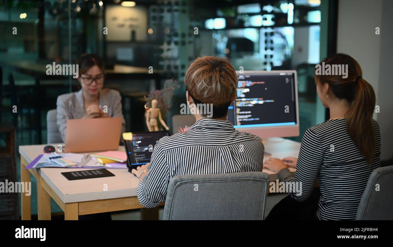 Software developers team brainstorming and programming in co working ...