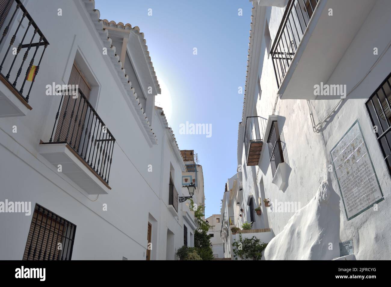 Sunlight in a typical white washed andalusian street, Frigiliana, Spain ...