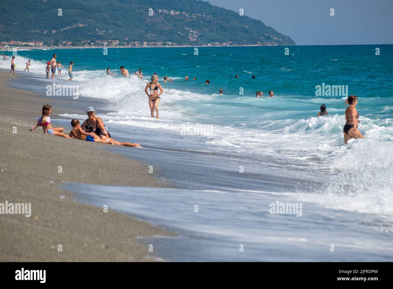 People having fun with the waves in the beach Stock Photo - Alamy