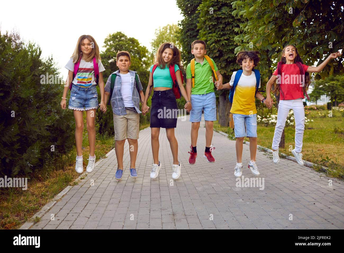 Funny elementary school students with backpacks on their shoulders have ...