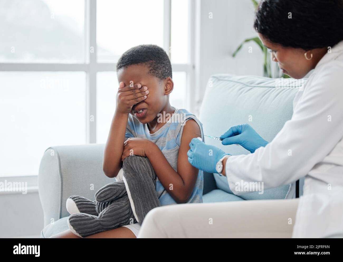 How sore will it be. Shot of a little boy looking scared while getting ...