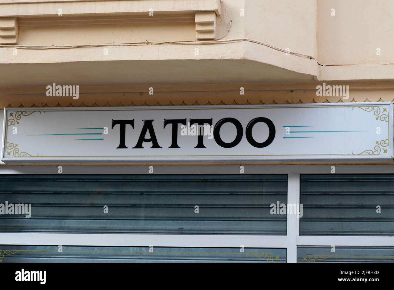 Tattoo text sign in letters on white background wall shop facade in the ...