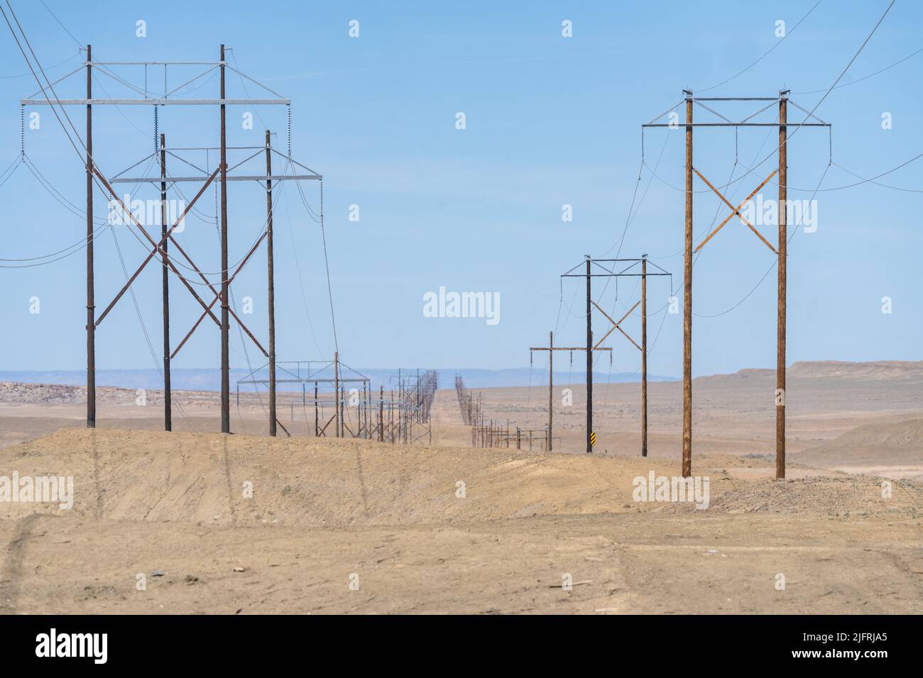 Wooden power transmission line towers stretch out across the barren ...