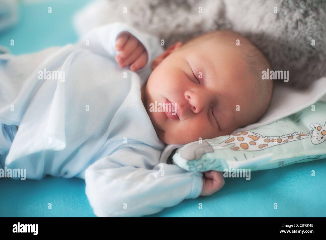 Cute little peaceful baby calm sleeps soundly in his crib in a bright ...