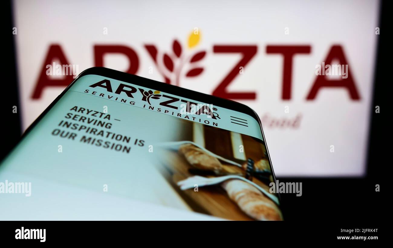 Mobile phone with webpage of Swiss food company Aryzta AG on screen in ...