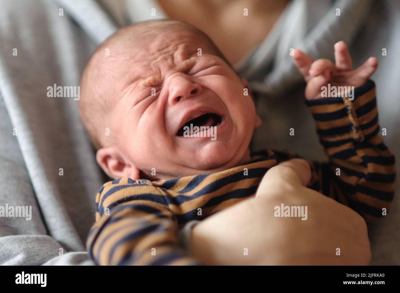 Sweet and cute small little newborn baby is hungry and upset and cry ...
