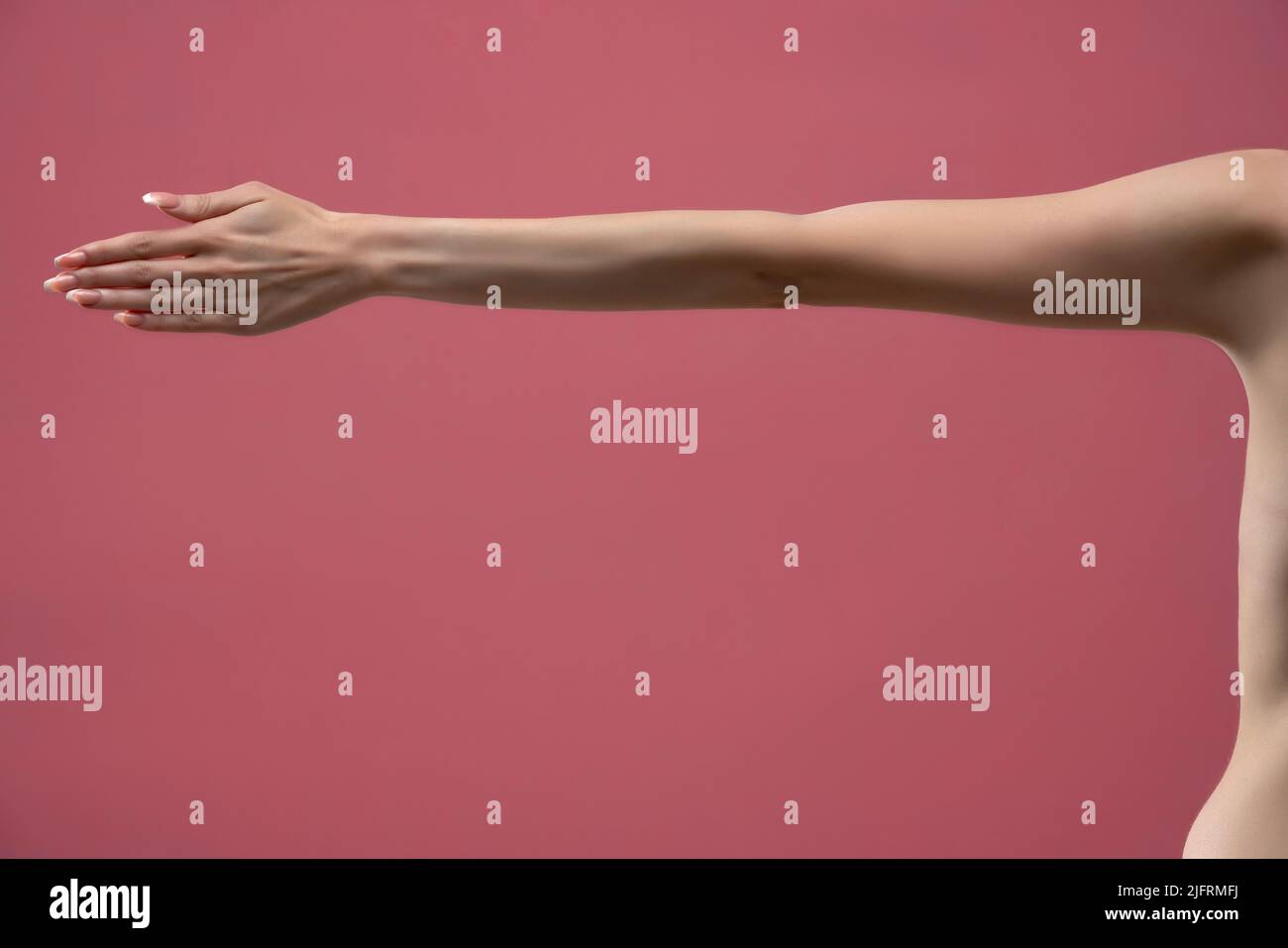 Young woman's stretched arm and palm. Isolated on pink background Stock ...