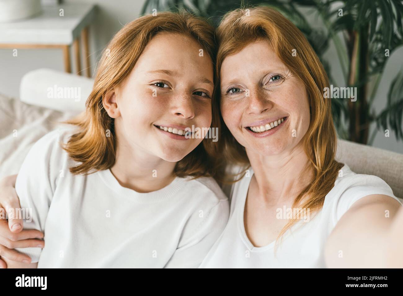 Mom and daughter pressed cheek to cheek and sincerely smile Stock Photo ...