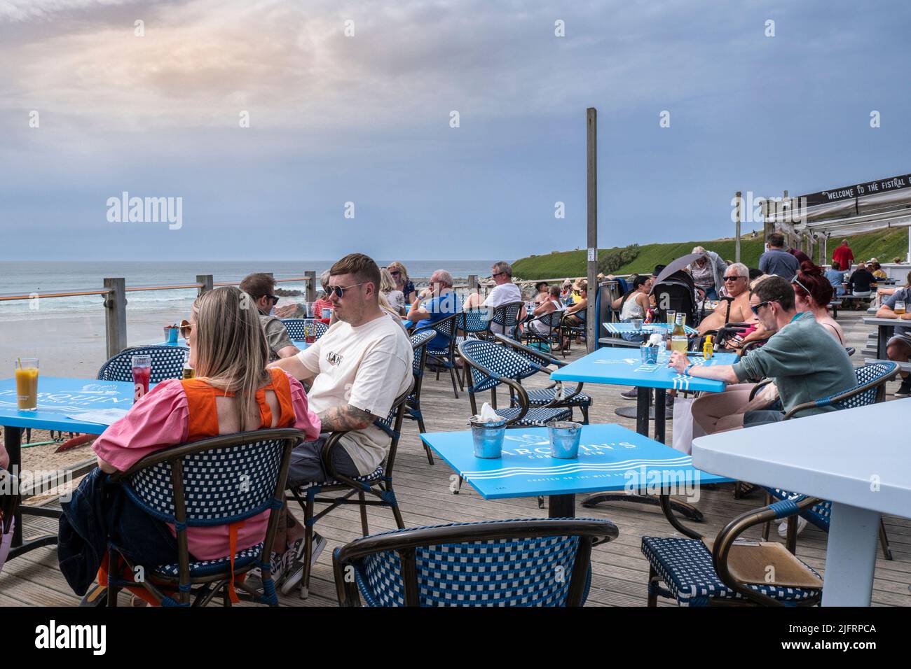 Holidaymakers relaxing on the outdoor decking area of the Fistral Beach ...