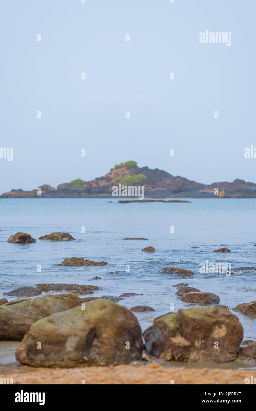rocks at om beach seashore. rock mountain in the back Stock Photo - Alamy
