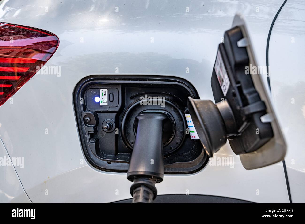 electric car being charged (detail) cable plug and socket of an ...