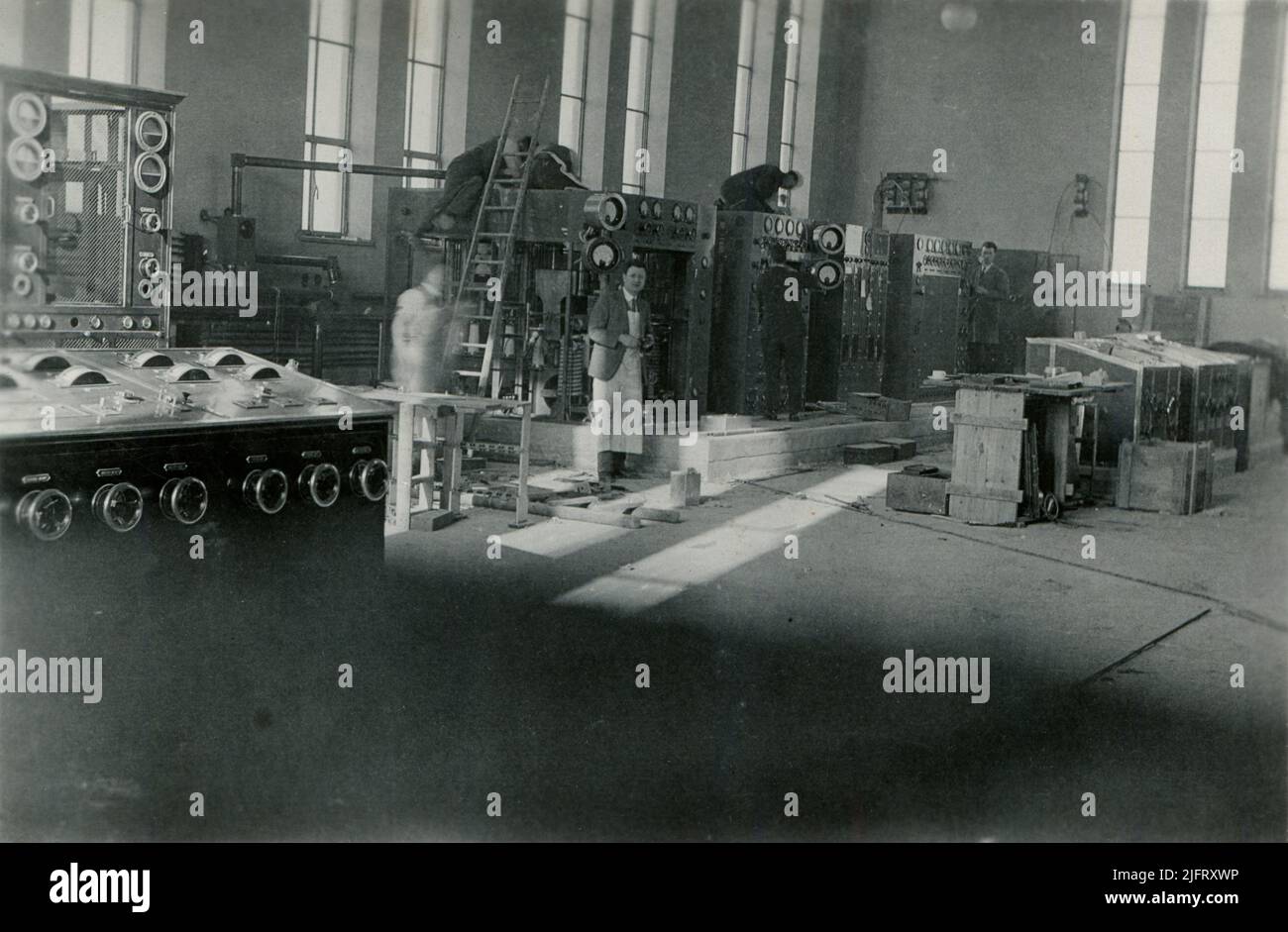 1930s. Engineers constructing equipment in a radio transmitting station ...