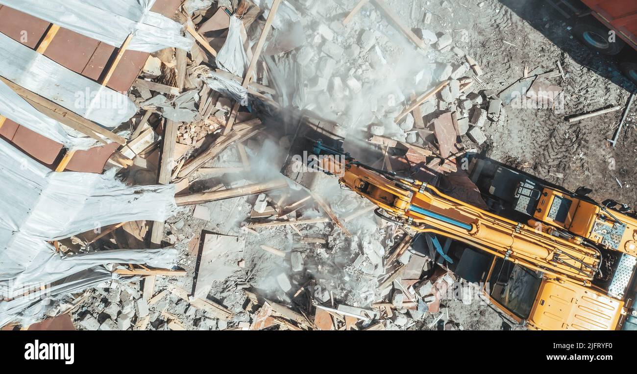 Demolition building aerial top view. Yellow excavator destroy old house ...