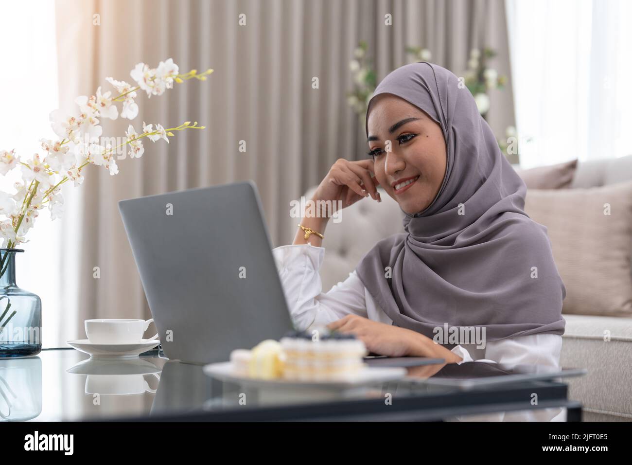 Muslim young women wear hijab using computer laptop at home morning ...