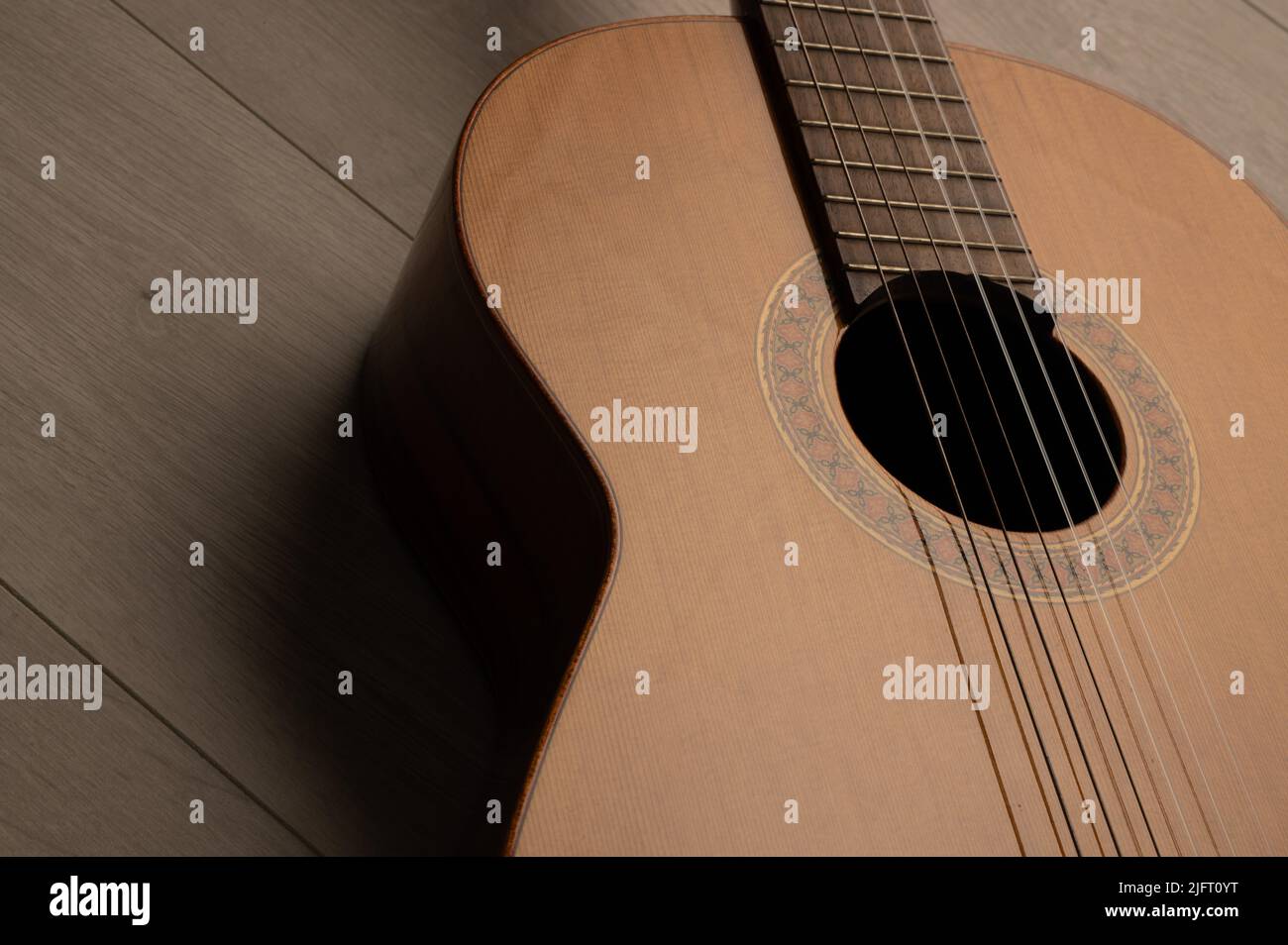 Classical guitar body close up, on a light wood background with copy ...