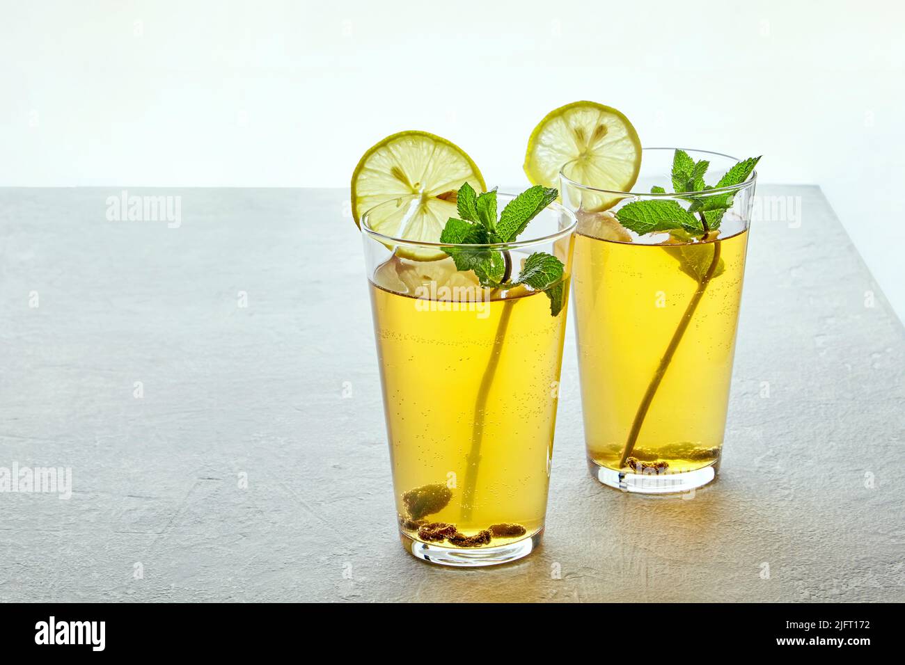 Two glass cups of homemade fermented kombucha tea are decorated with ...