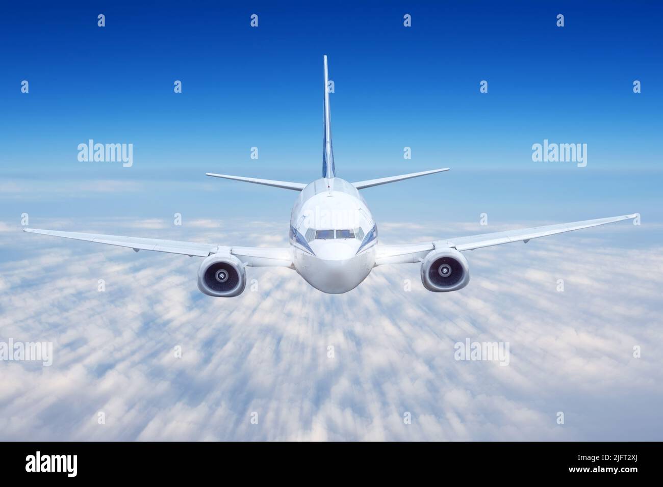 Airplane with motion blur effect is flying over low cloudt. Business ...