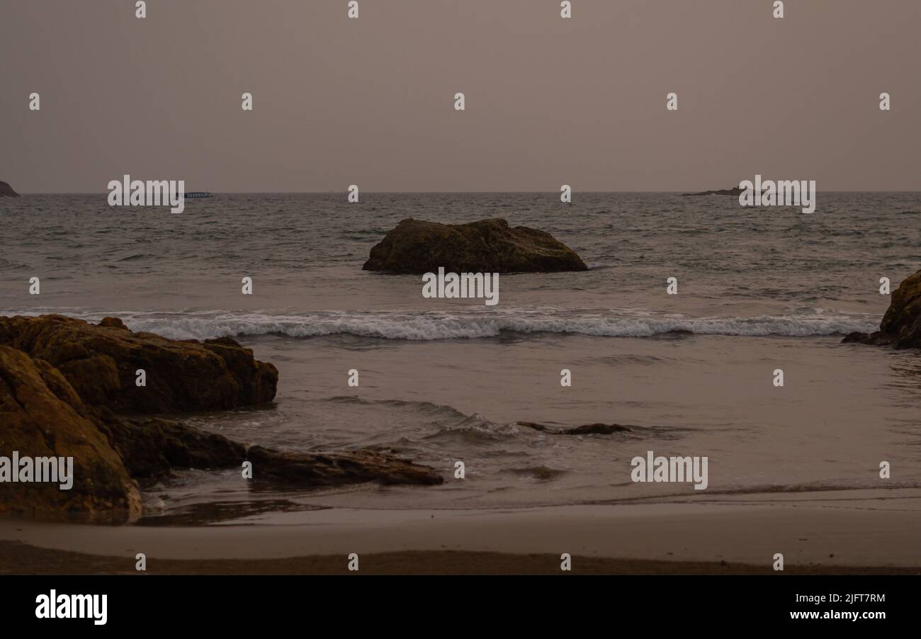 single wave coming through the two rocks at seashore.Wave hitting stone ...