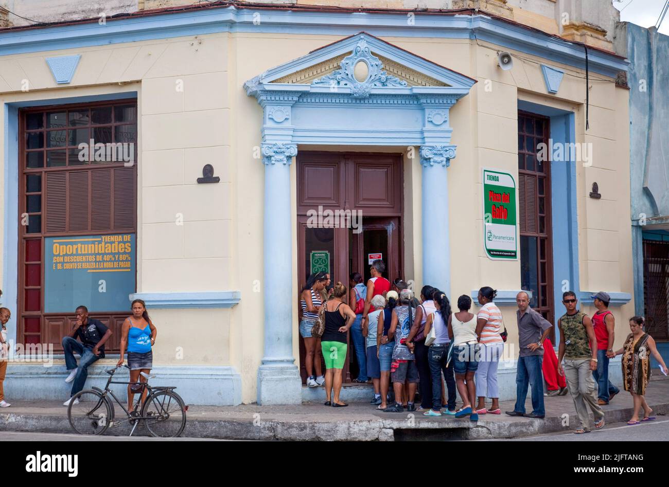 Cuba, Camaguey, Peopleare waiting in front of a building. Because ...