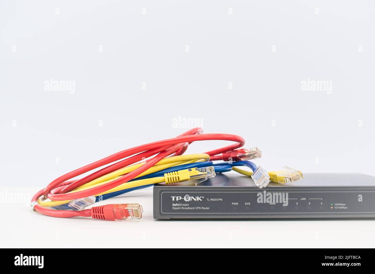 TP-LINK gigabit broadband network router with network cables on a white ...