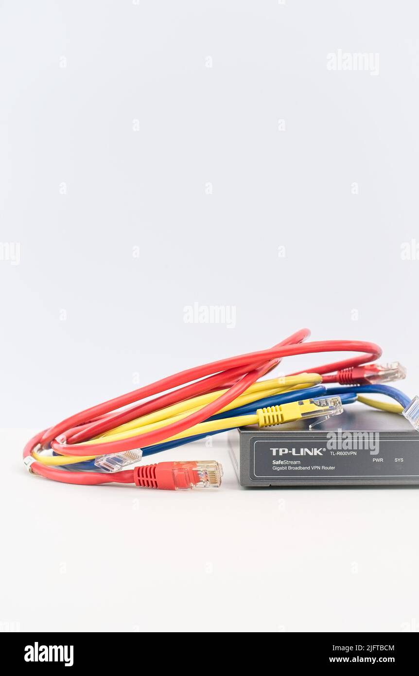 TP-LINK gigabit broadband network router with network cables on a white ...