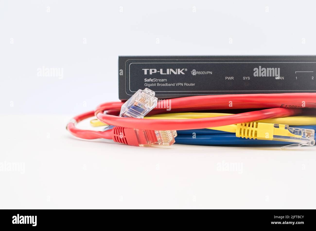 TP-LINK gigabit broadband network router with network cables on a white ...
