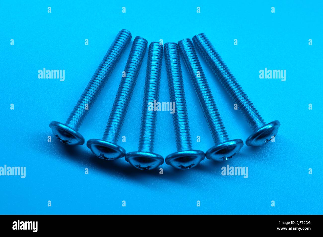 Set of six screws on a light blue background. Macro photo. Background ...