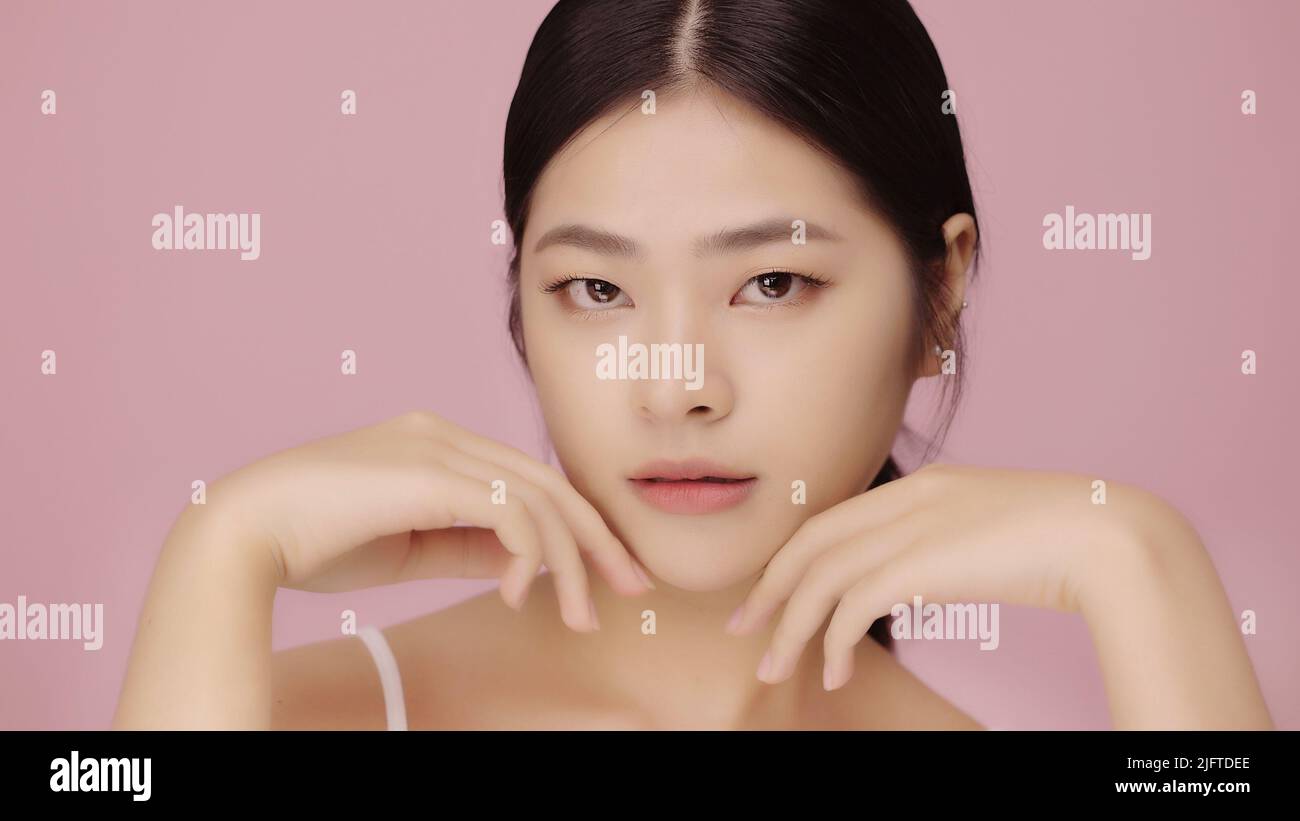 Close up face of beautiful young Asian woman with clear skin lifting ...