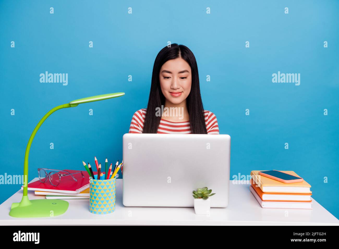 Photo of charming positive vietnamese lady sitting desk use wireless ...