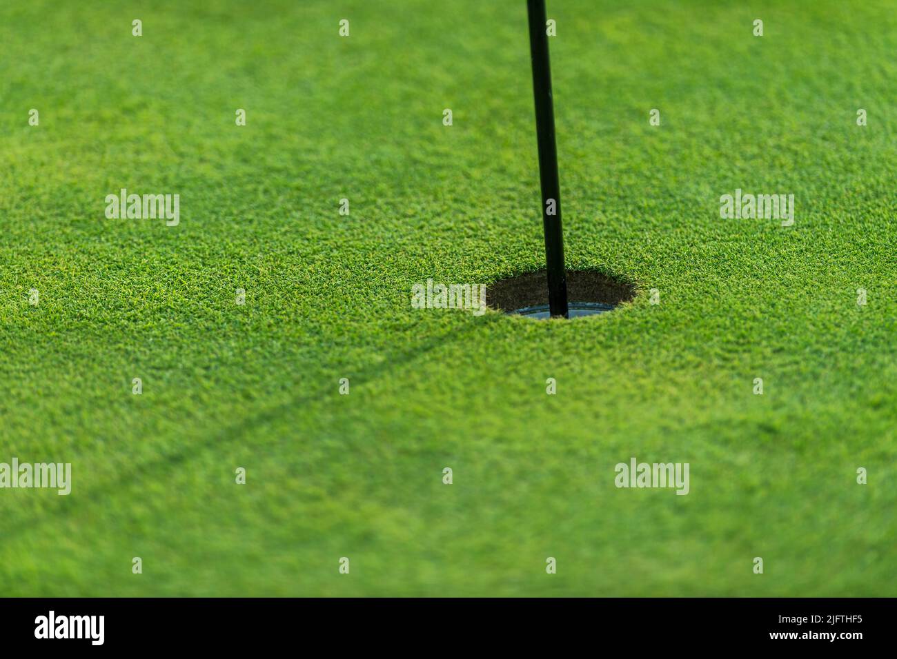 Flag and hole at the beautiful golf course. Horizontal sport theme ...