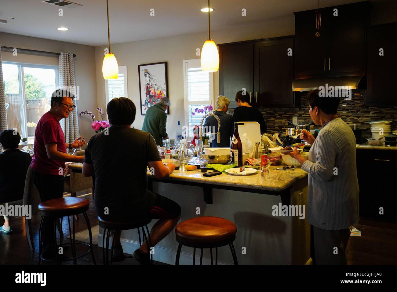 Albert and his families and friends chat as they eat and drink during ...