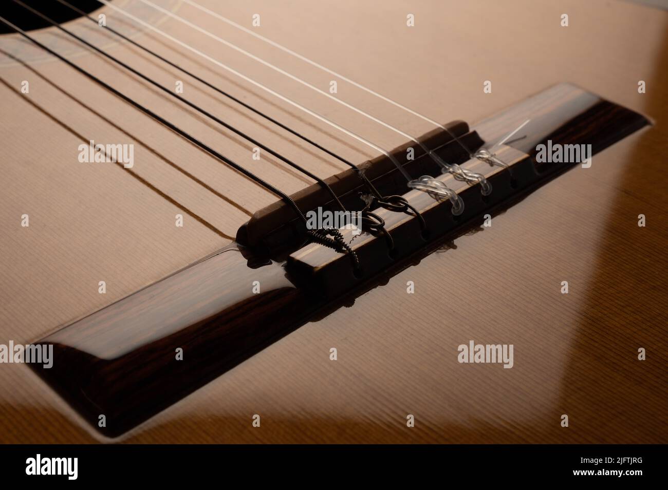 Spanish classical six string guitar bridge and saddle close up with a ...
