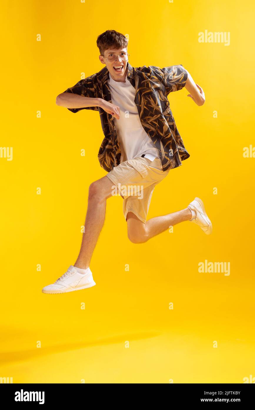 Full-length man's portrait isolated on bright yellow studio backgroud ...
