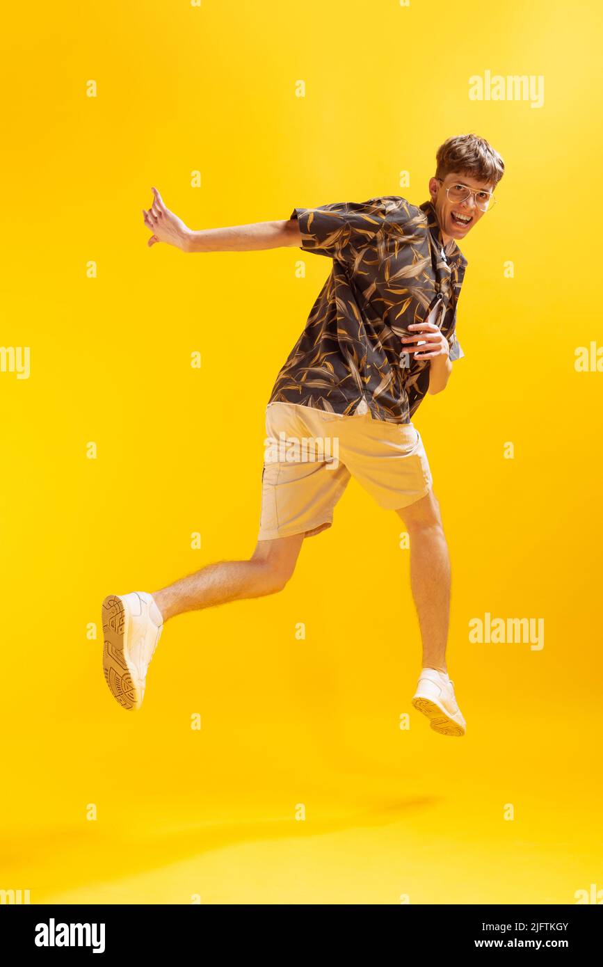Full-length man's portrait isolated on bright yellow studio backgroud ...