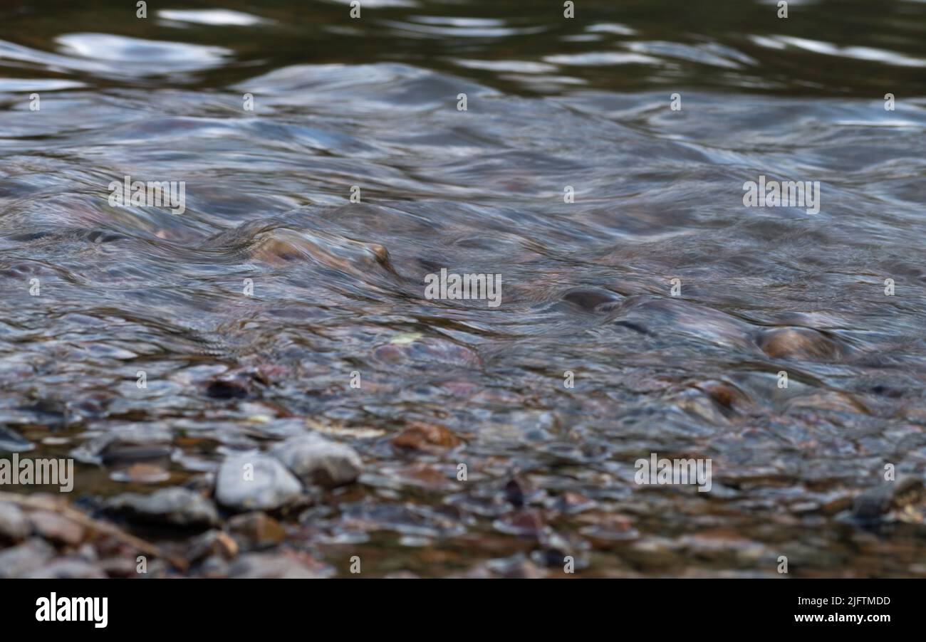 Shallow stream rapid flow over gravel close up, detail from fast creek ...