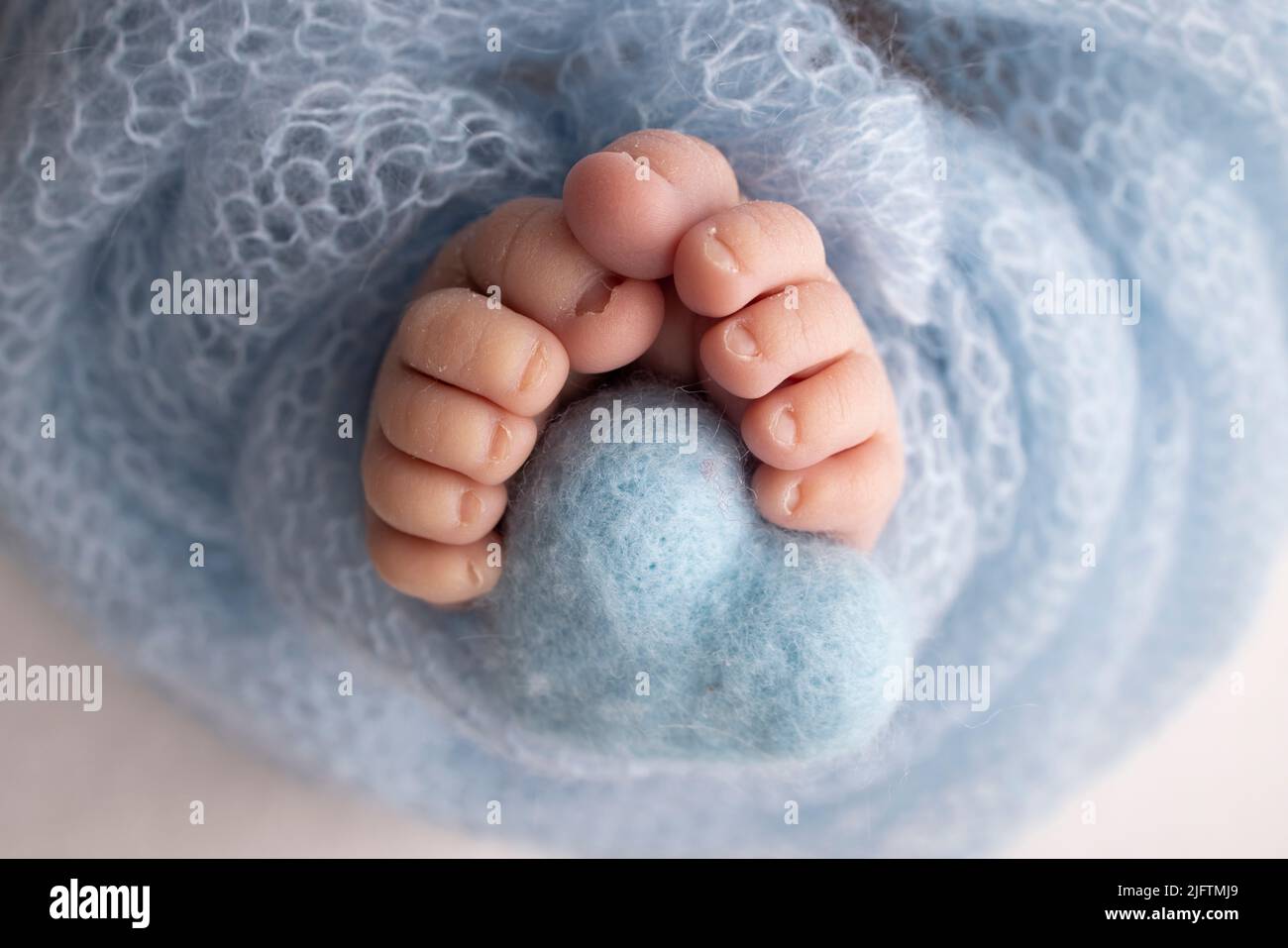 The tiny foot of a newborn baby. Close up of toes, heels and feet of a ...