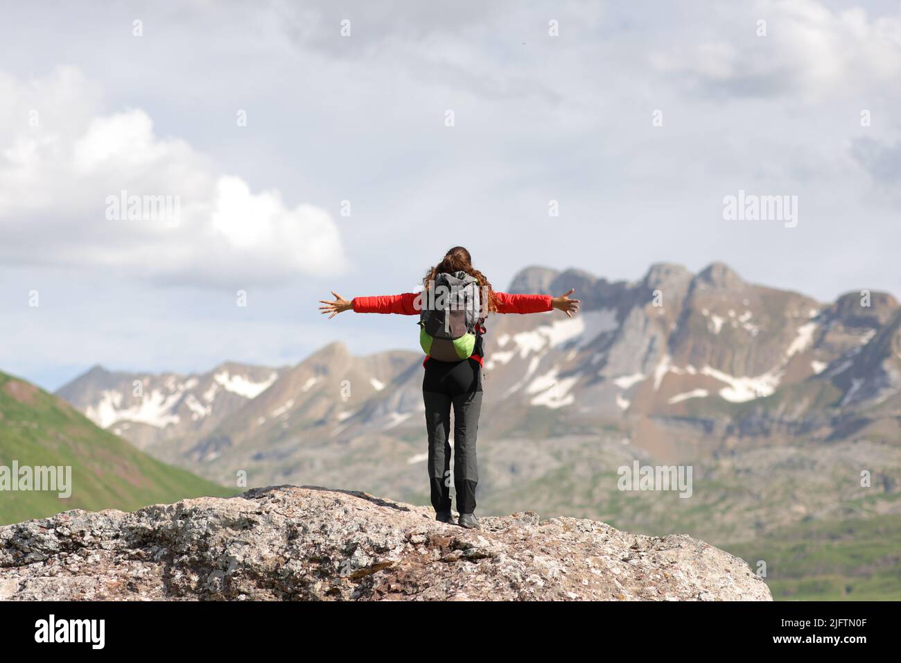 Back view portrait of a hiker celebrating vacation in the top of a high ...