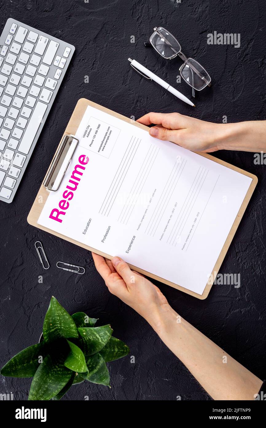 Employer reviews resume application form on office table Stock Photo ...