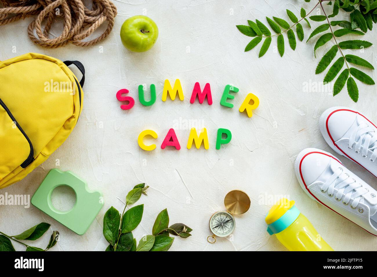 Summer camping background with backpack sneakers green tree branches ...